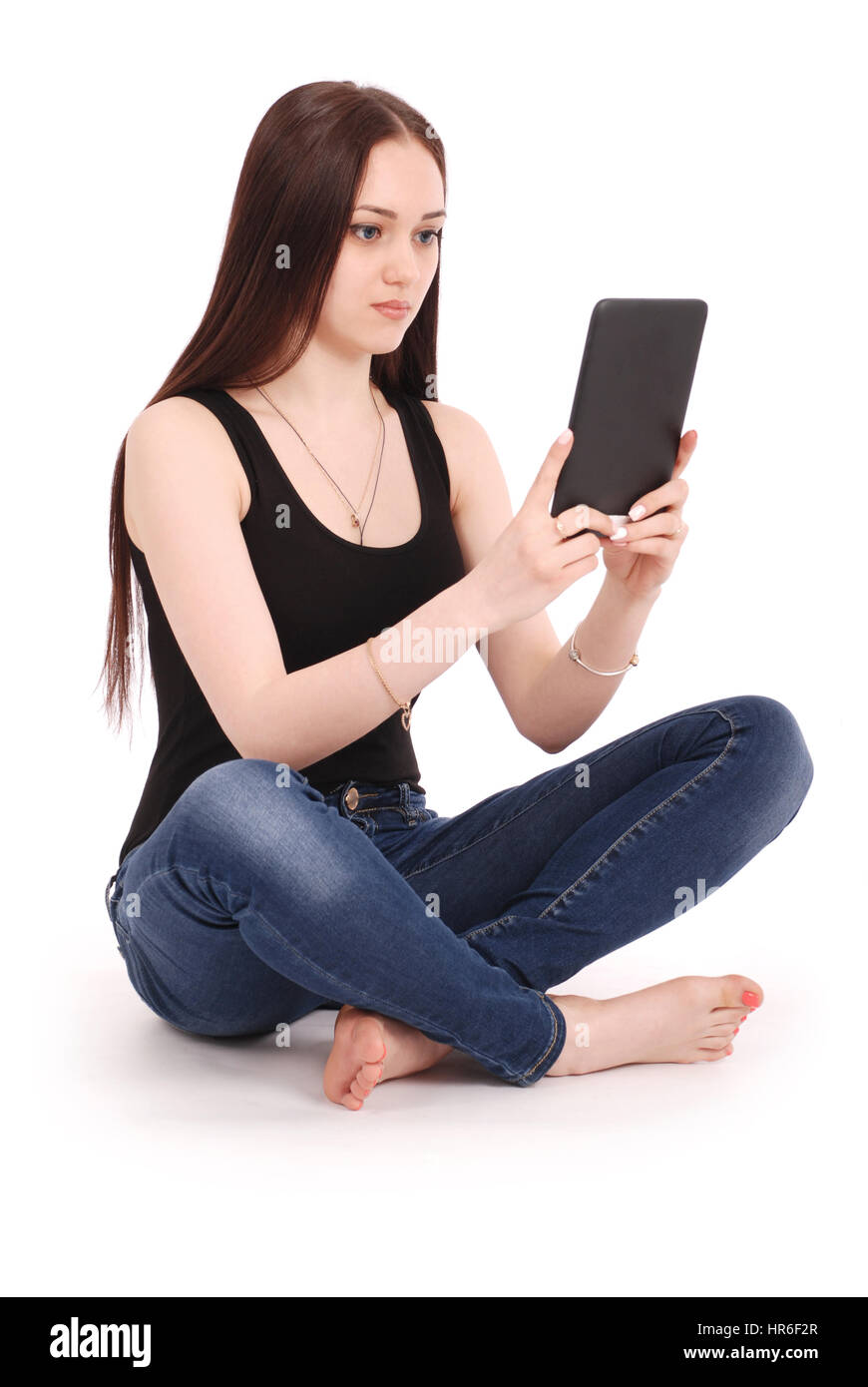 Student teenage girl sitting sideways on the floor with tablet pc ...