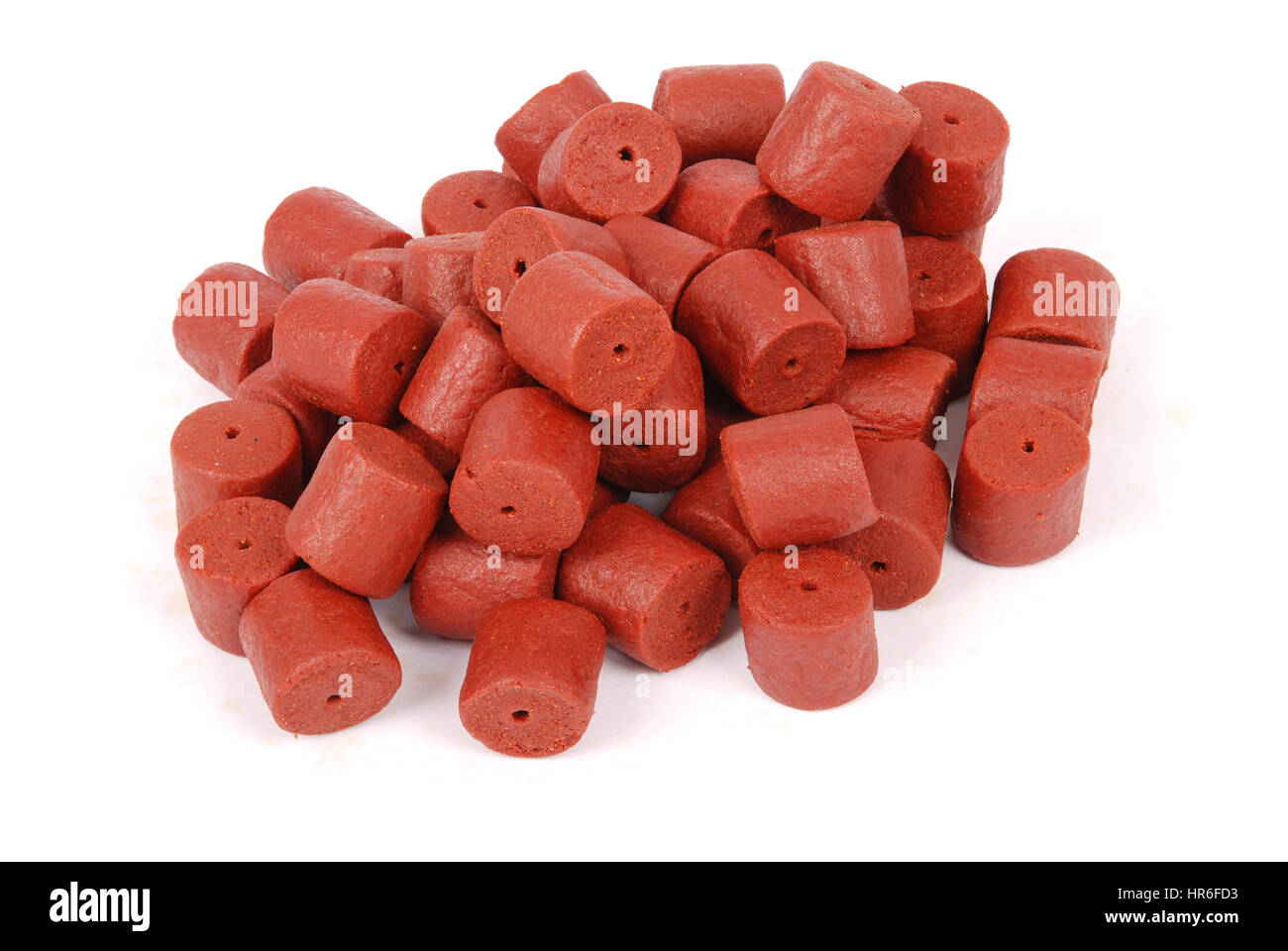 Red pre-drilled halibut pellets for carp fishing isolated on white ...