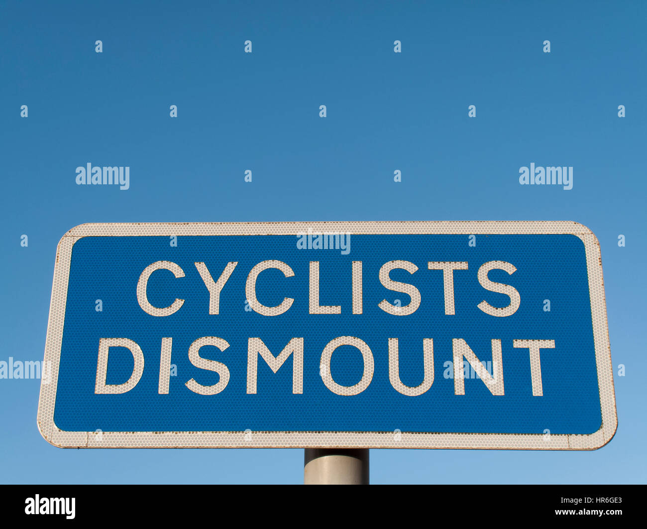Cyclist dismount road sign against a clear blue sky Stock Photo - Alamy