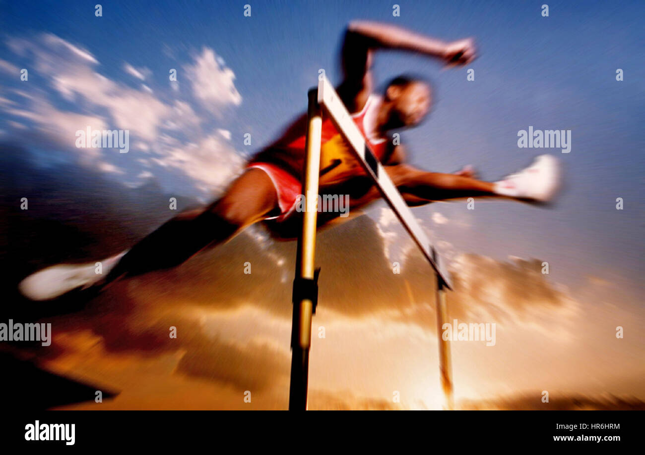 HURDLER Dramatic low angle view of hurdler flying over a hurdle at ...