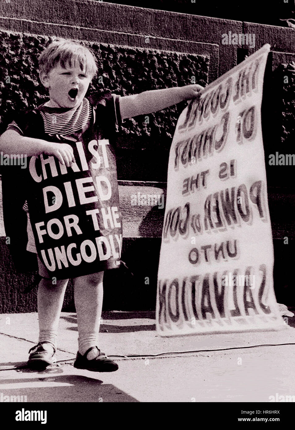 B+W 1960s Young boy at religious rally waving banner and preaching ...