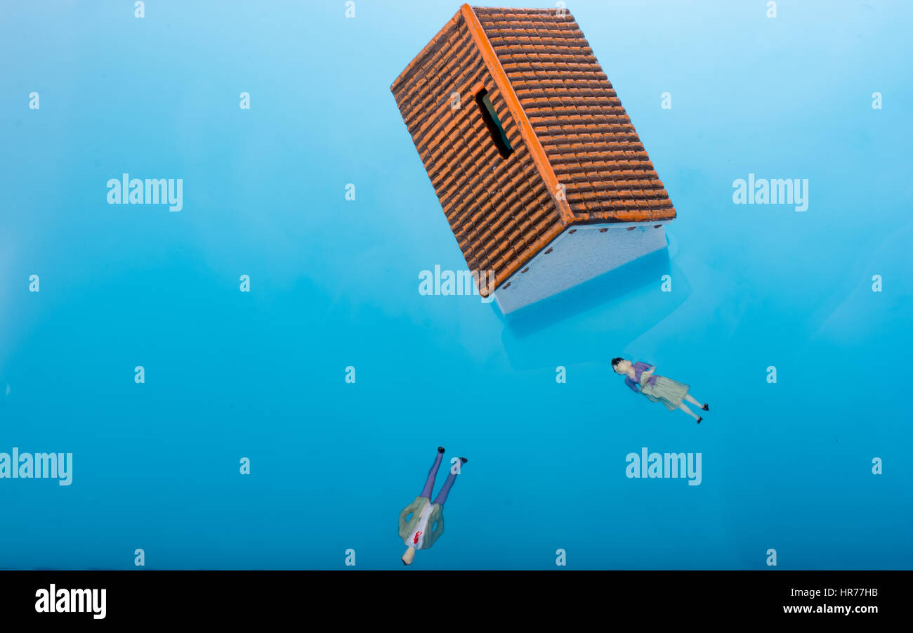 Little model house and figurines of man and woman float in water Stock ...