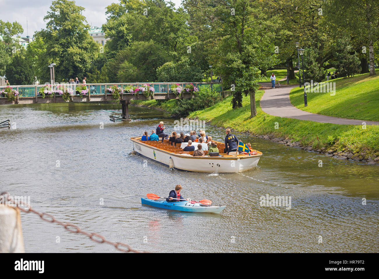 Sightseeing boat with tourists enjoying the view at a canal in ...