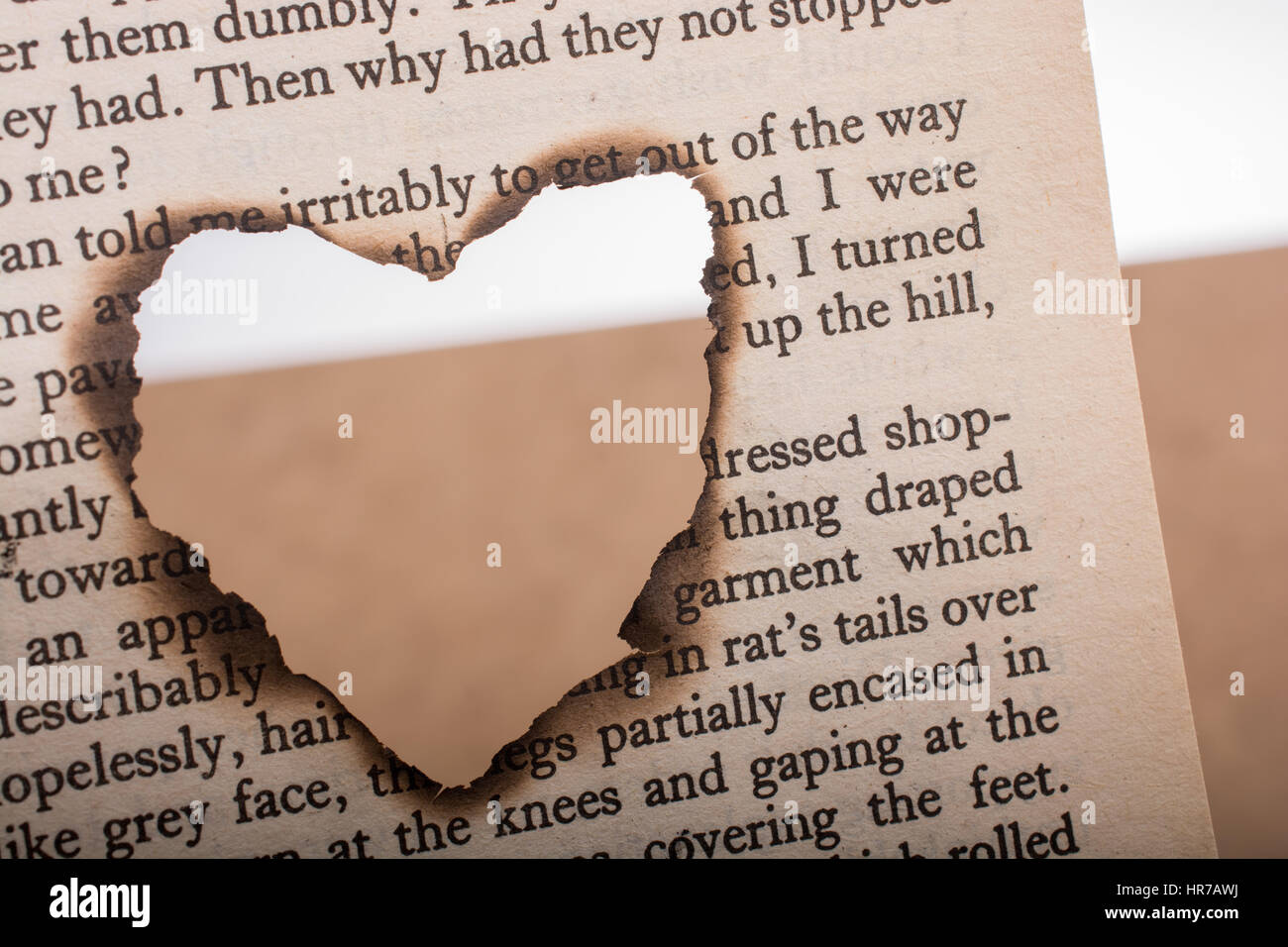 Heart shaped burnt out of a texted paper Stock Photo - Alamy