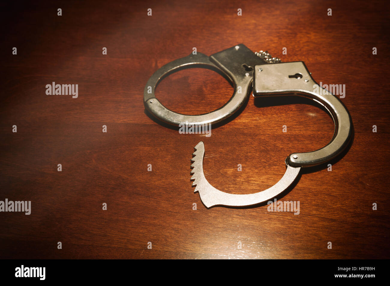 Metal handcuffs with dark background, close up Stock Photo - Alamy