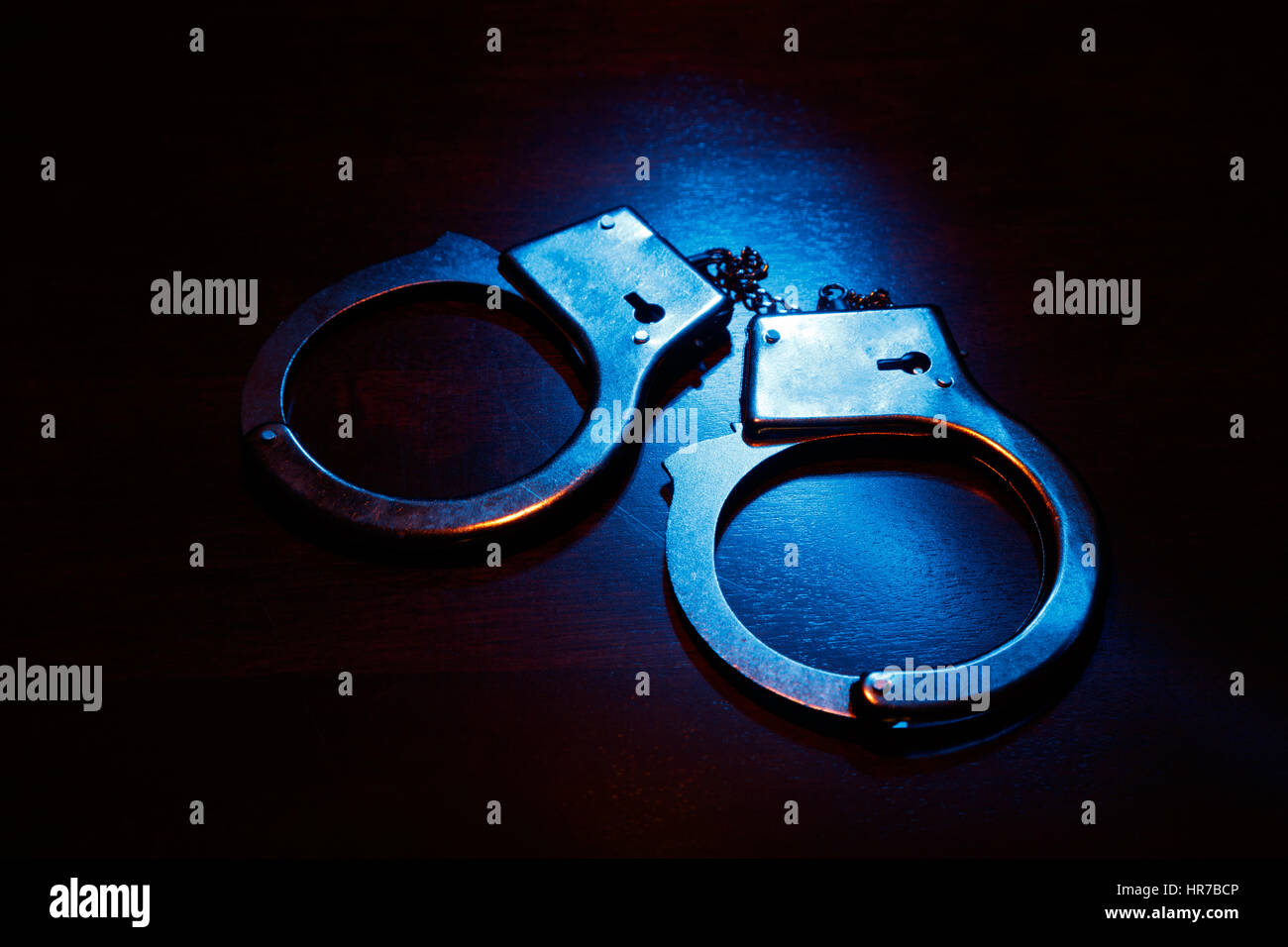 Metal handcuffs with dark background, close up Stock Photo - Alamy