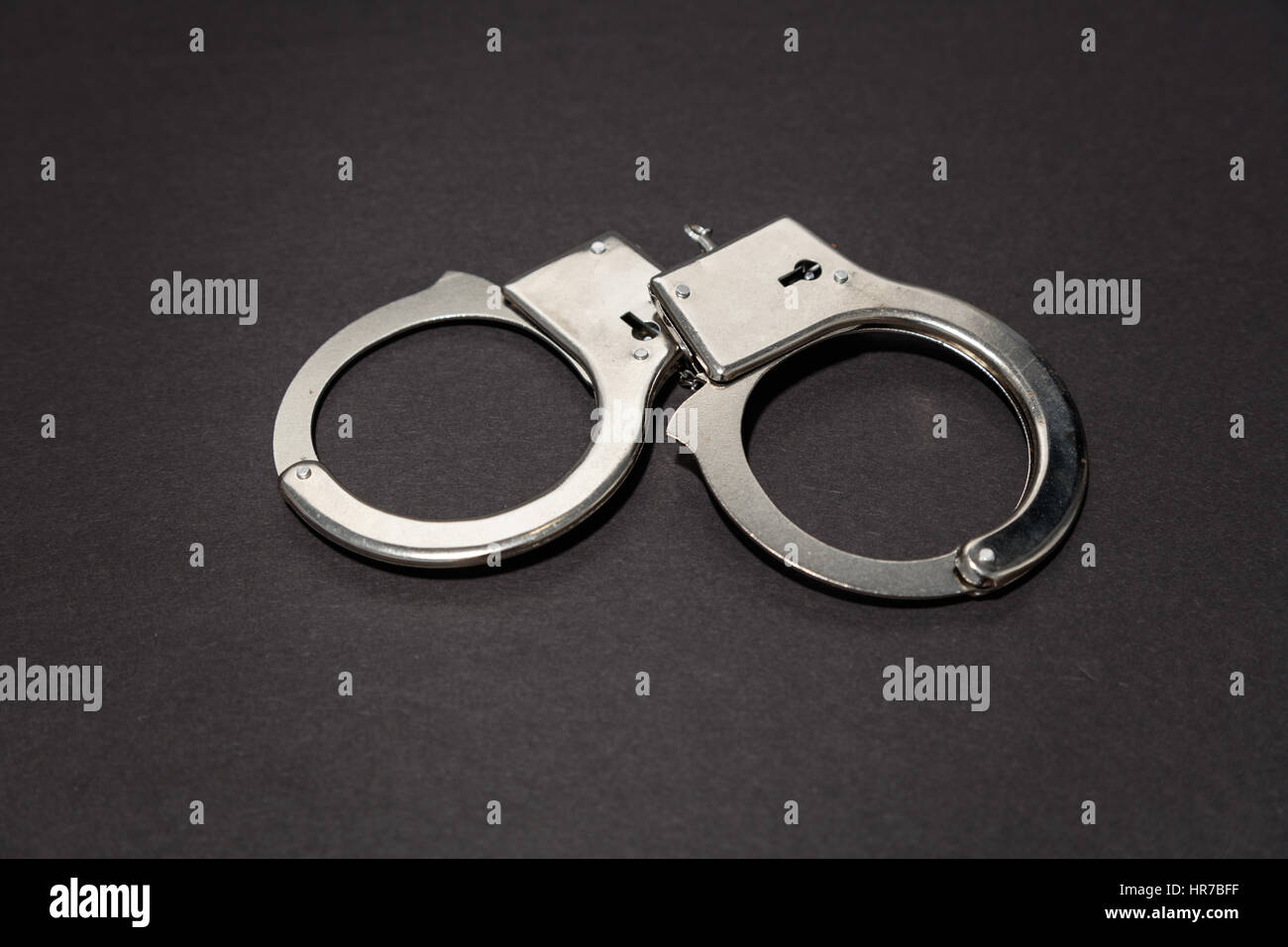 Metal handcuffs with dark background, close up Stock Photo - Alamy