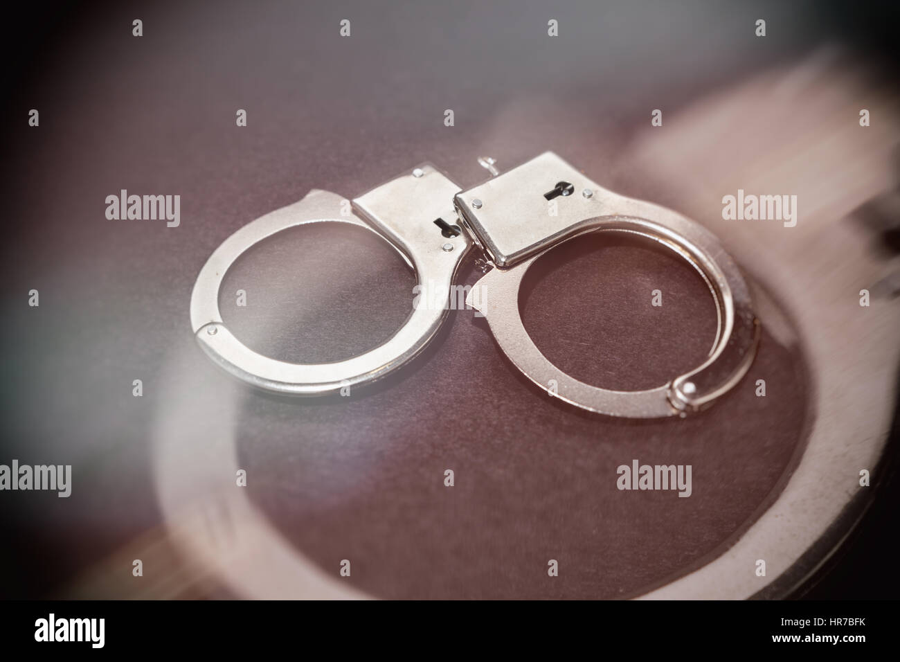 Metal handcuffs with dark background, close up Stock Photo - Alamy