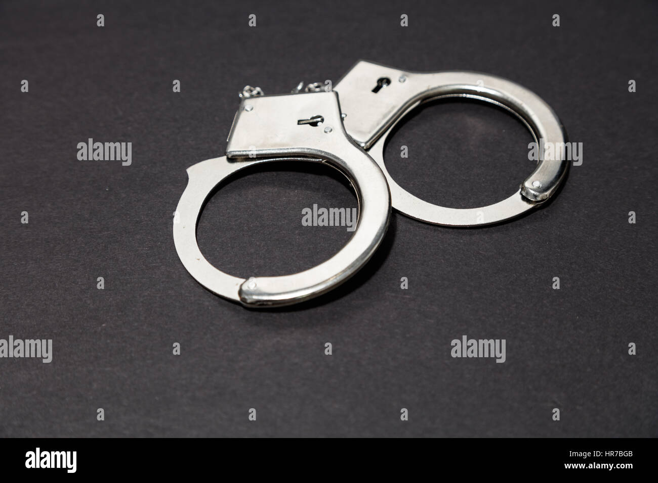 Metal handcuffs with dark background, close up Stock Photo - Alamy