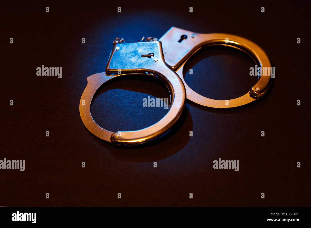 Metal handcuffs with dark background, close up Stock Photo - Alamy