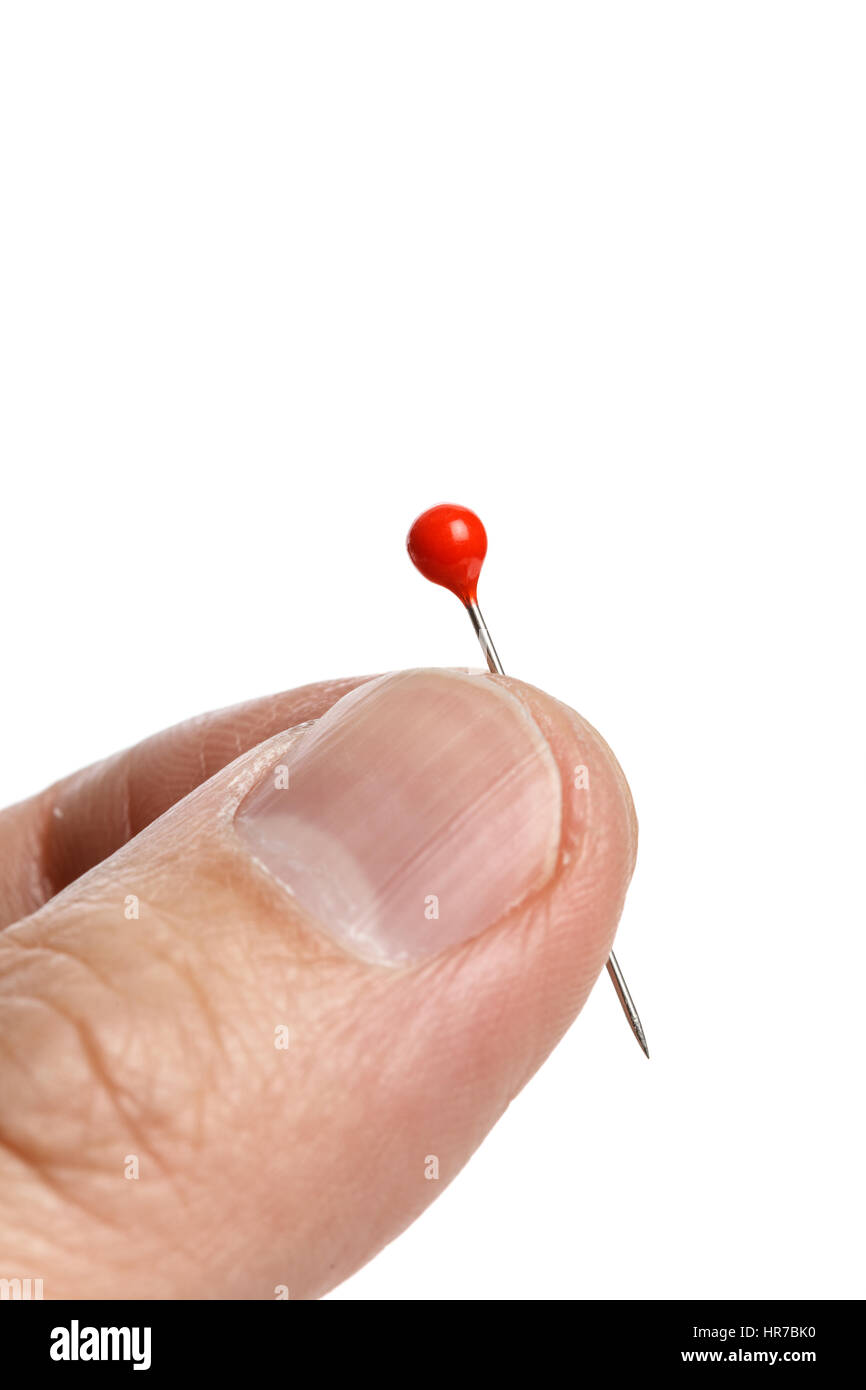 hand holding a pin with a red head, white background Stock Photo - Alamy