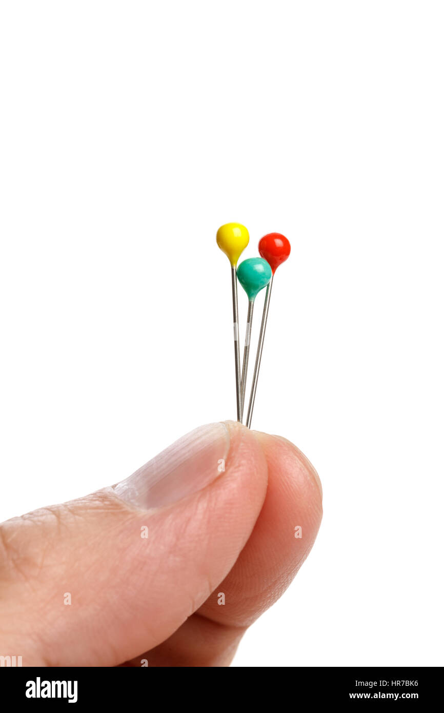 hand holding pins with a white background Stock Photo - Alamy