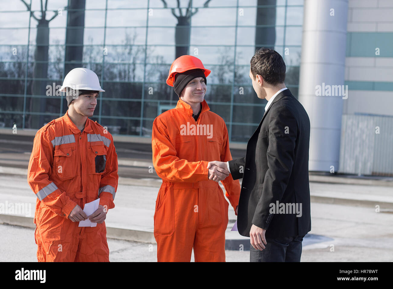 boss or Chief handshaking with workers engineers. Good job. Business ...