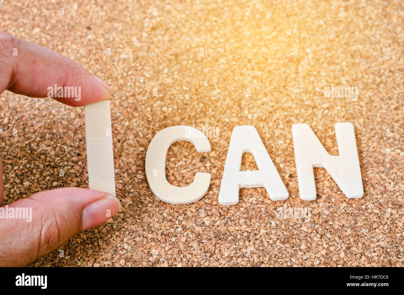 Hand arrange wood letters as I CAN word on wood background. Success and ...