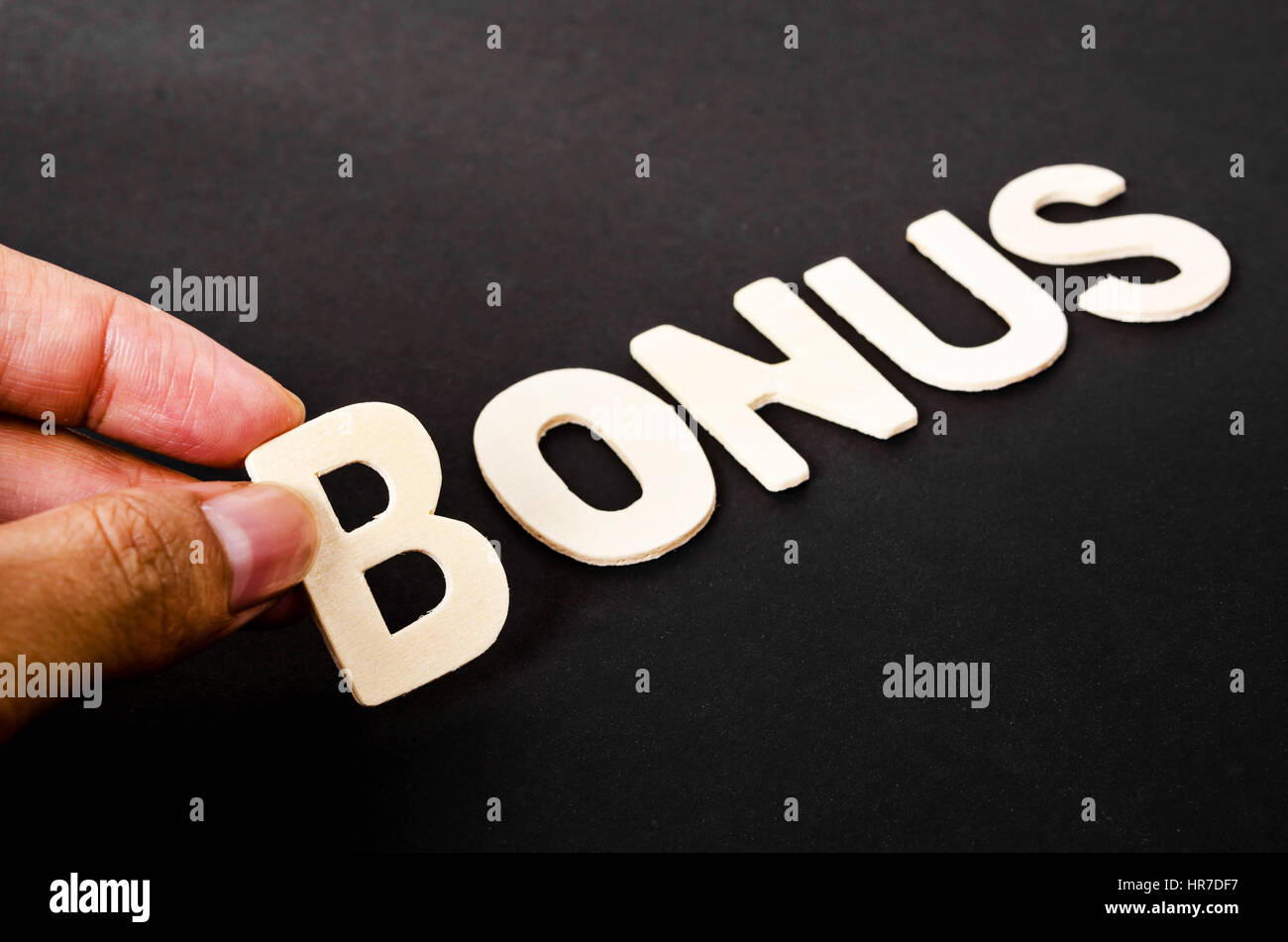 Hand arrange wood letters as Bonus word on black bakcground Stock Photo ...