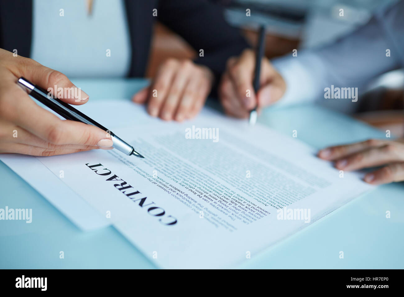 Closeup shot of two business partners signing contract at meeting ...