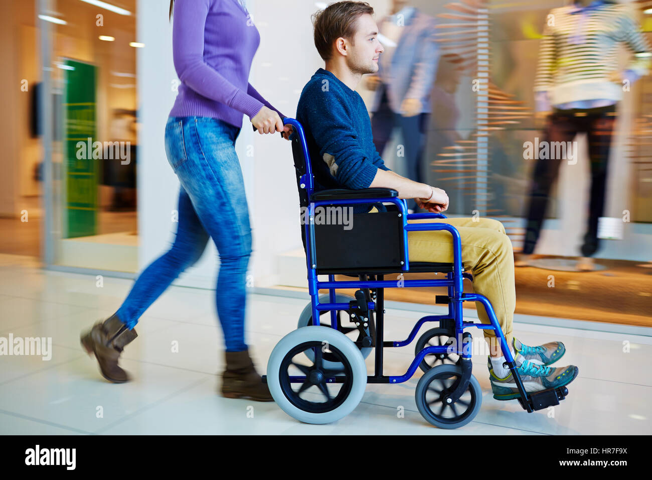 Physically impaired man in wheelchair doing shopping with his ...