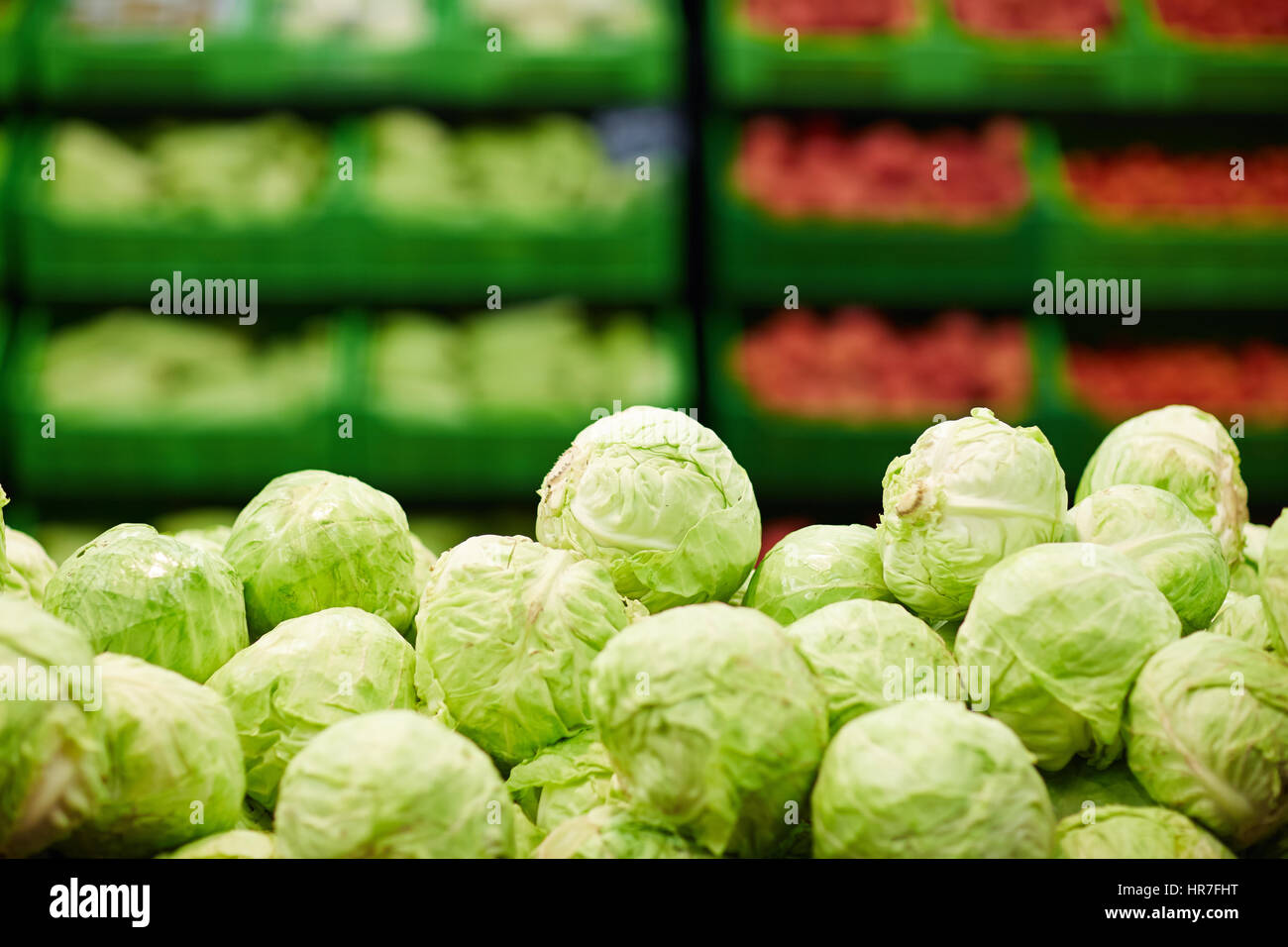 Supermarket stand with group of fresh green cabbages in fruit and ...
