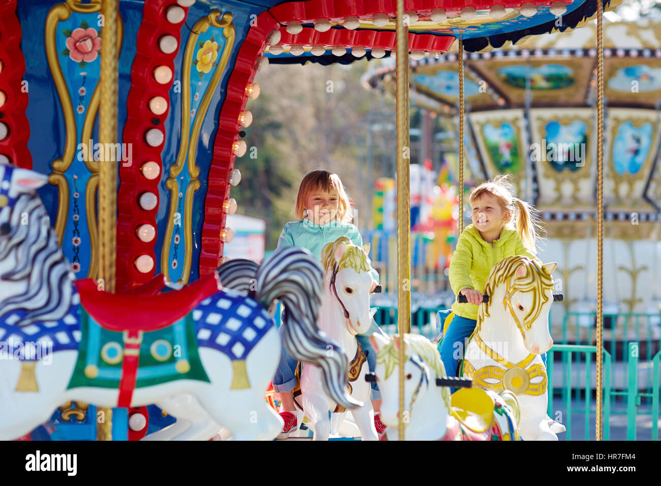 Two blond-haired little friends in jeans and bright windbreakers having ...