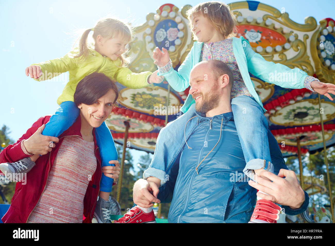 Carefree little girls playing with each other while sitting on ...