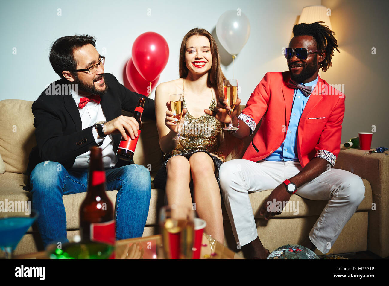 Attractive young woman with wide smile chatting and drinking alcohol ...