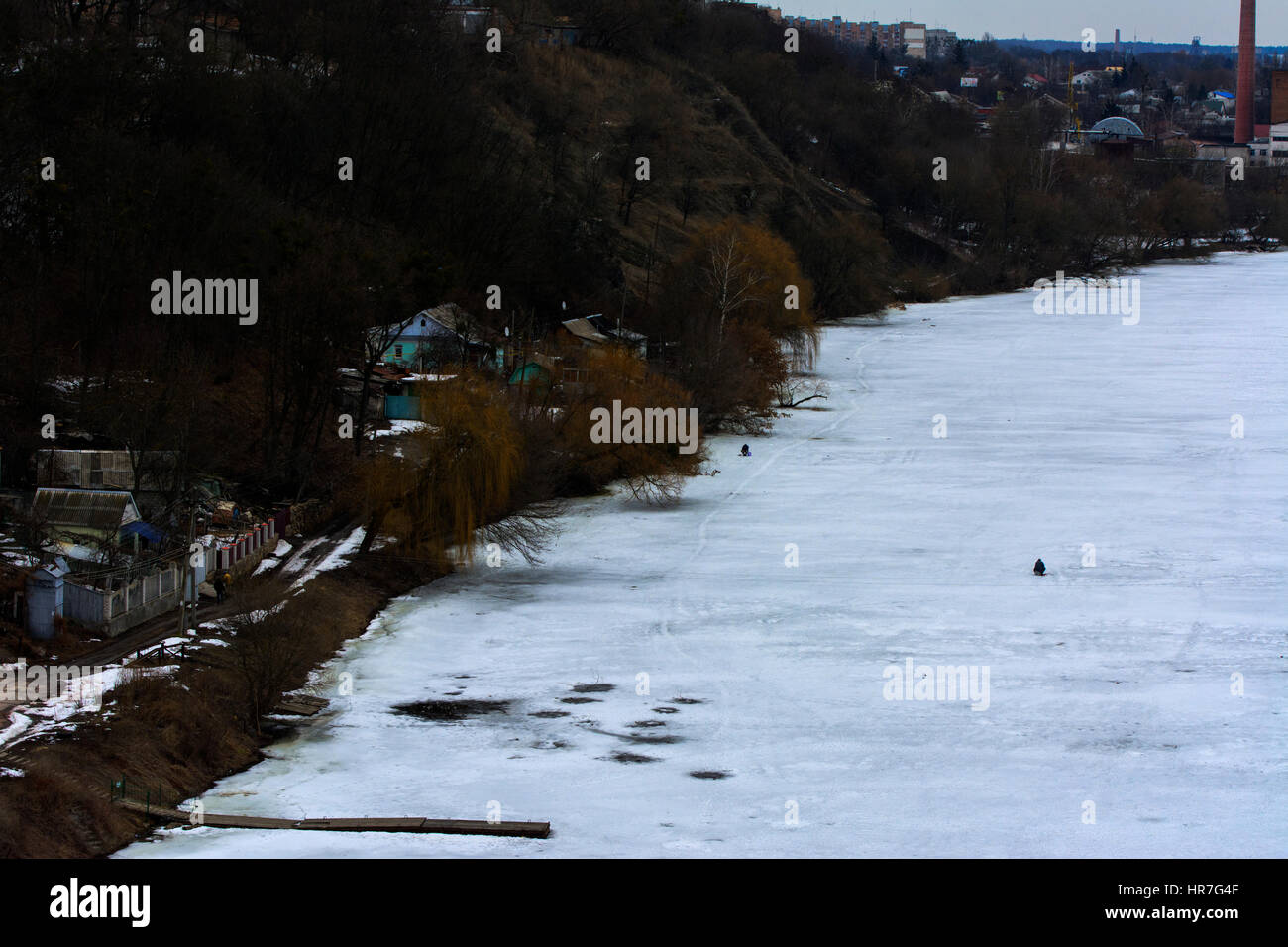 Fishermen on the river in winter ice fishing before the ice melting ...