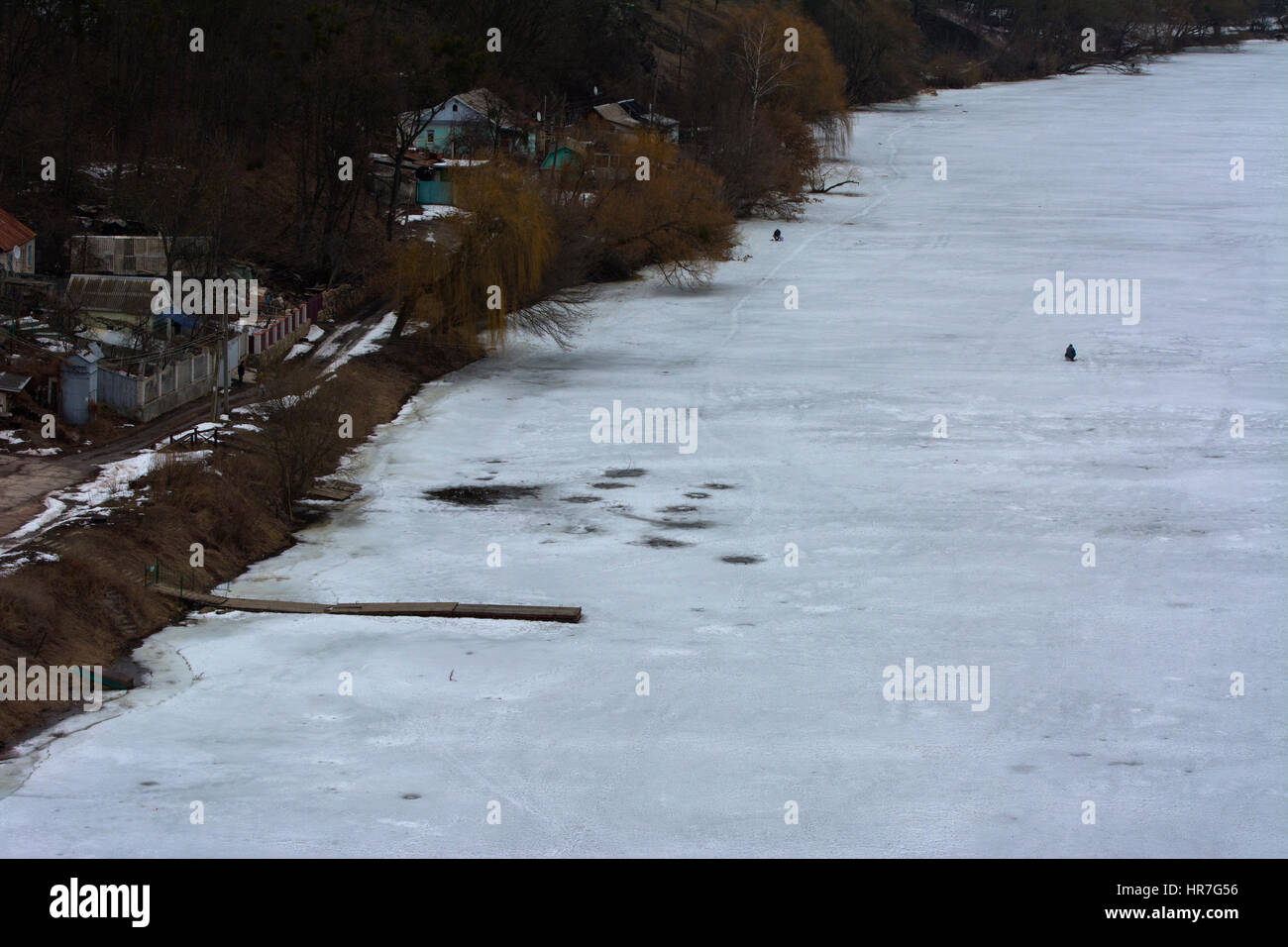 Fishermen on the river in winter ice fishing before the ice melting ...