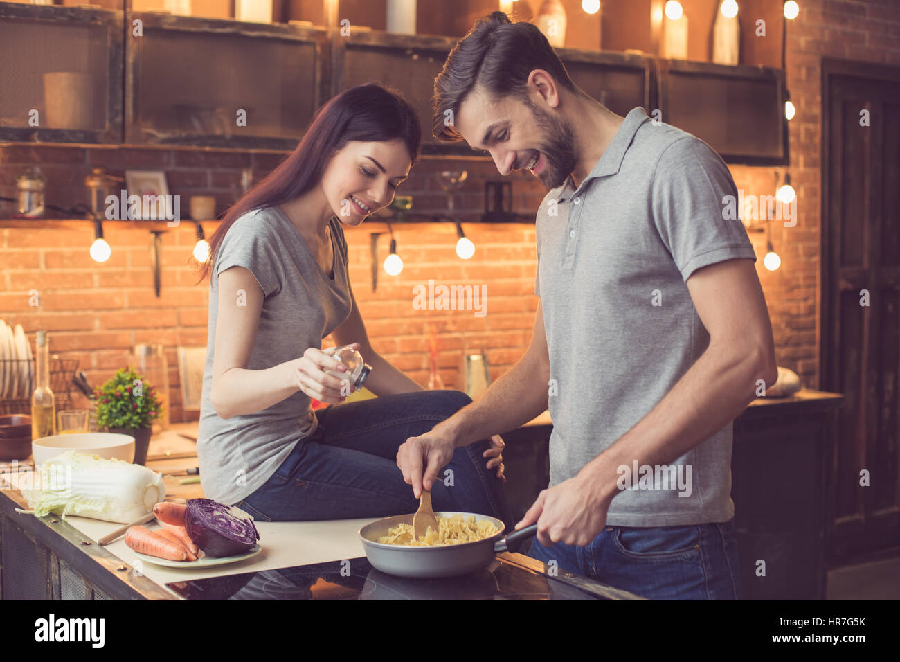Young beautiful couple in kitchen. Family of two preparing food. Woman ...