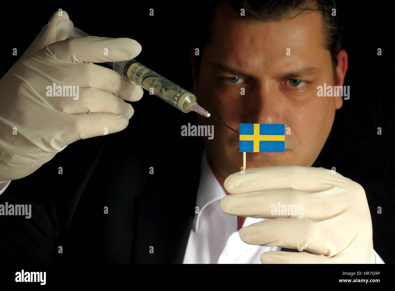 Young businessman gives a financial injection to Swedish flag isolated ...