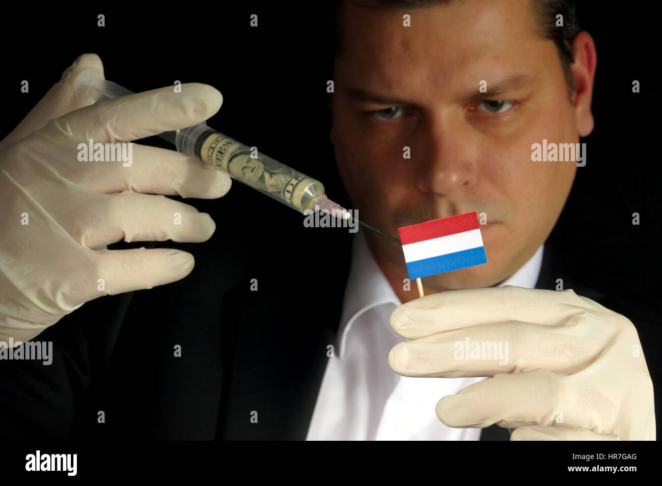 Young businessman gives a financial injection to Dutch flag isolated on ...