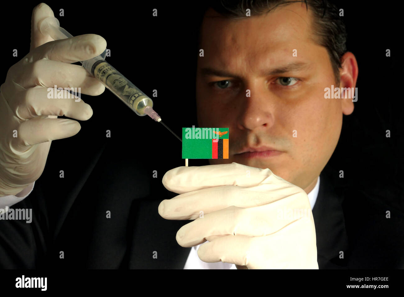 Young businessman gives a financial injection to Zambian flag isolated ...