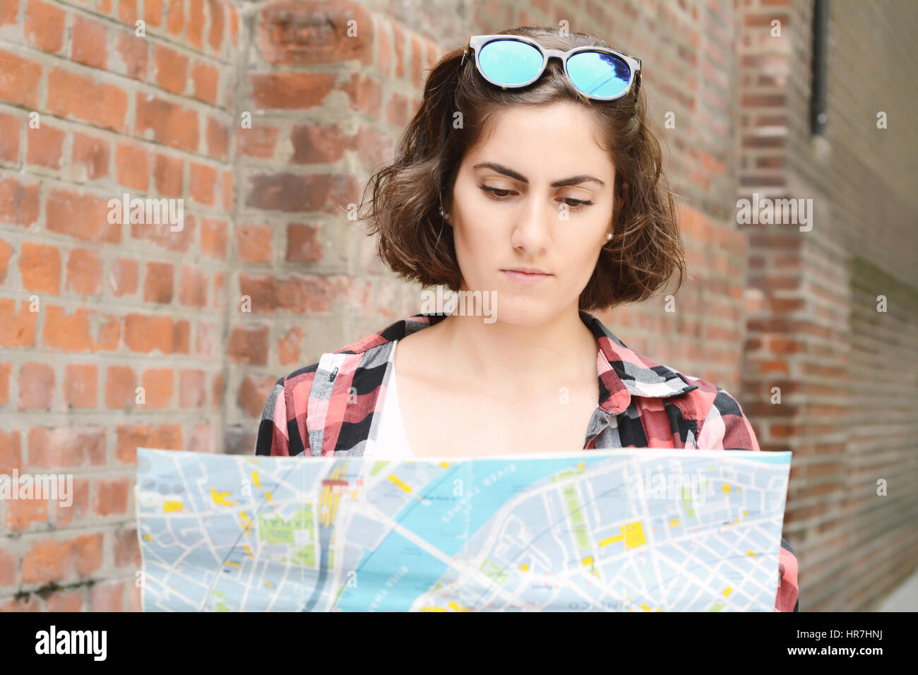 Portrait of a young beautiful tourist looking at a map. Tourism concept ...