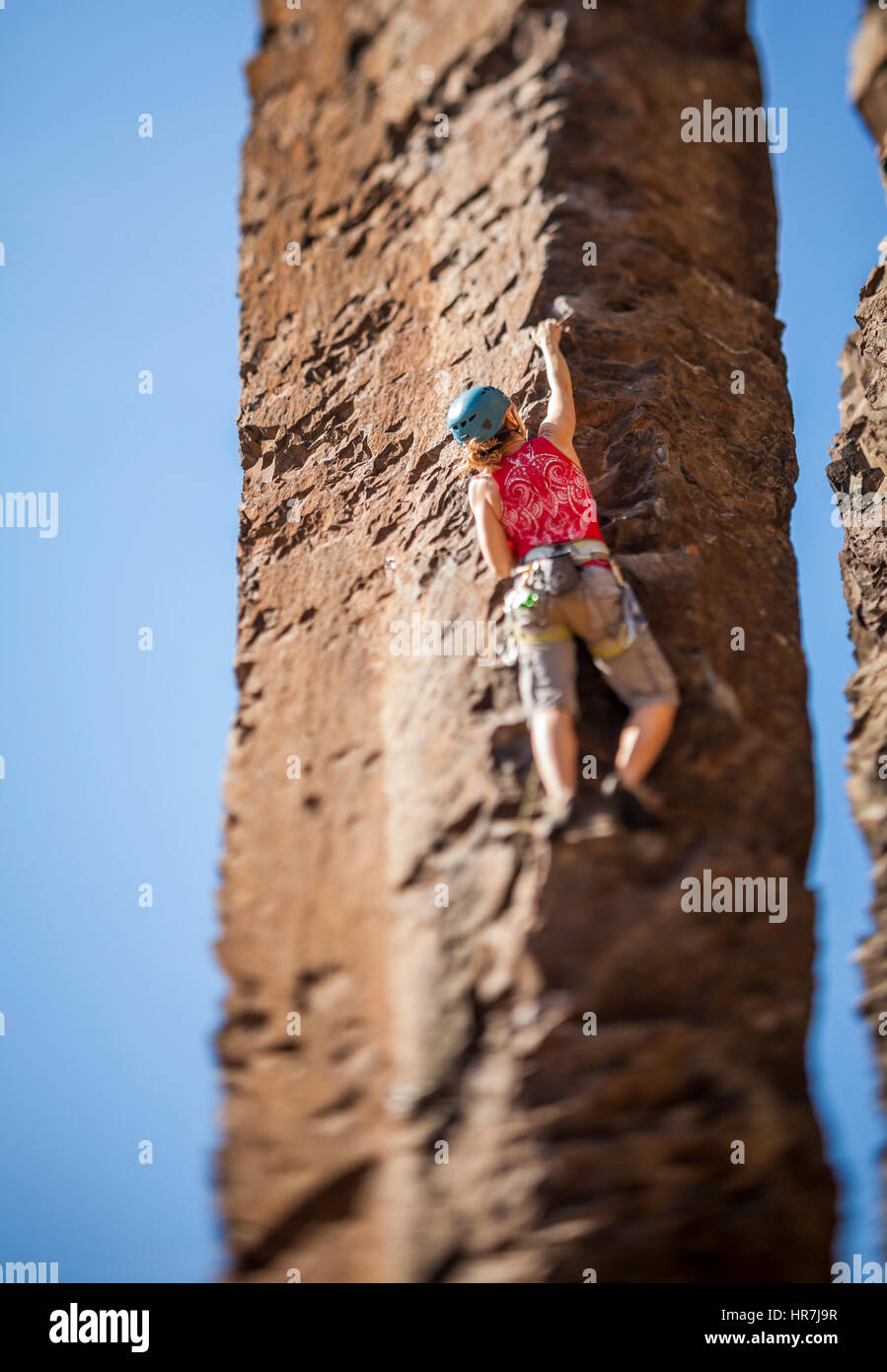 A woman rock climbing on a free standing pillar of basalt at Frenchman ...