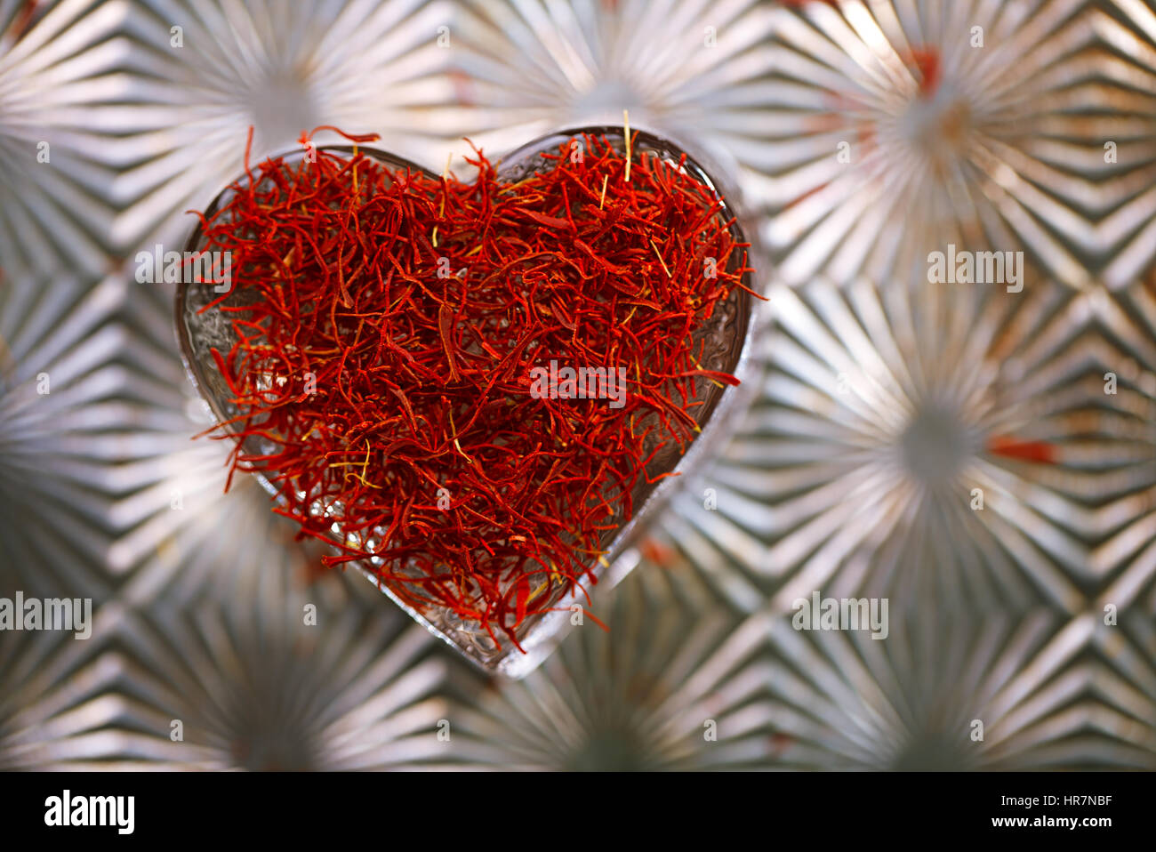 saffron space threads with heart shape glass and metal background Stock ...