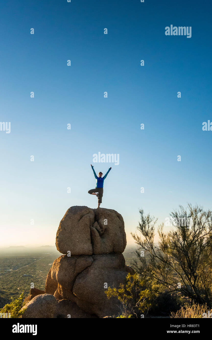 A woman doing a yoga "Tree" pose atop a boulder in Pinnacle Peak Park ...
