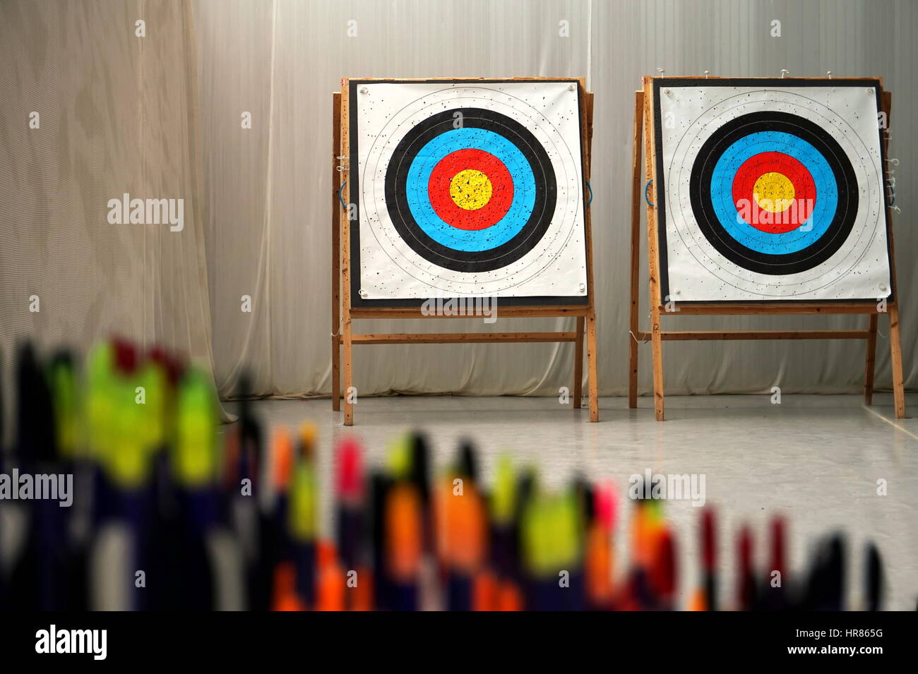 Archery arrows out of focus with targets in background Stock Photo - Alamy