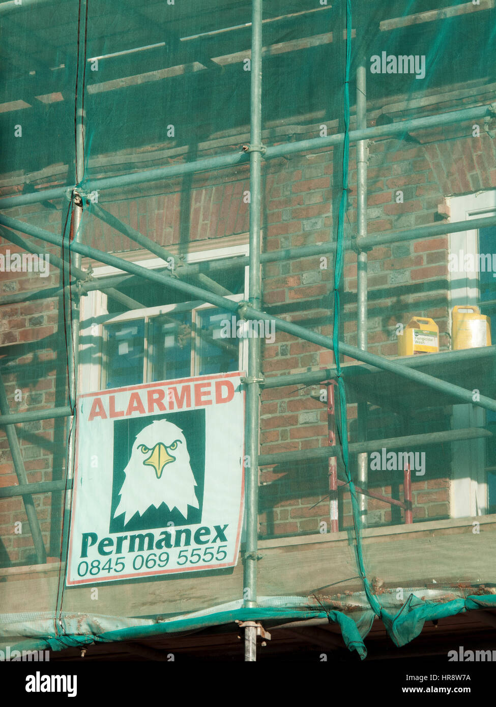 Scaffolding erected over retail premises with Permanex alarmed sign and ...