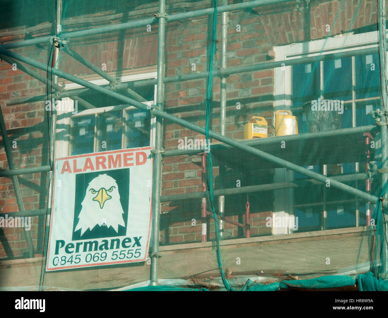 Scaffolding erected over retail premises with Permanex alarmed sign and ...