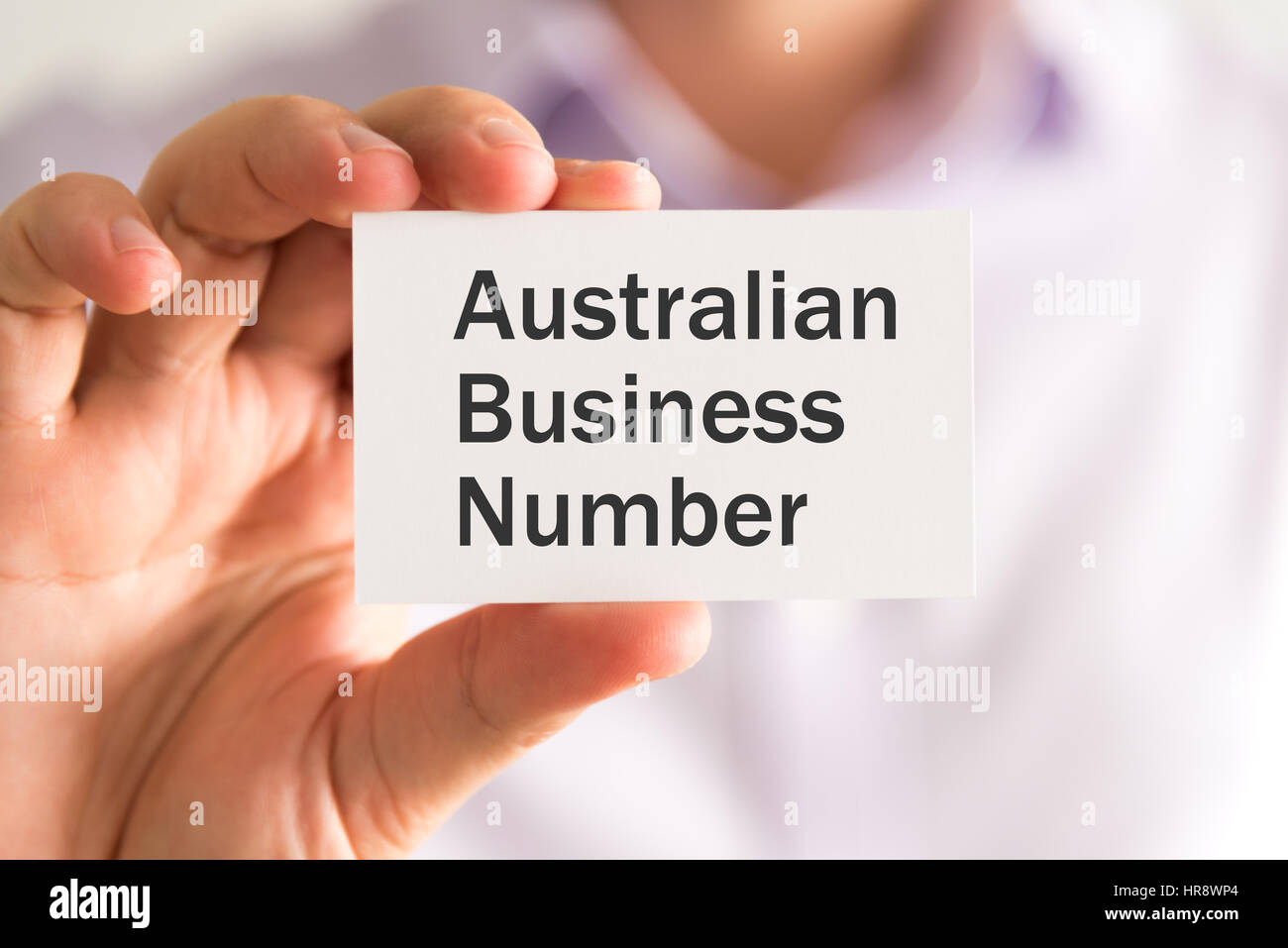 Closeup on businessman holding a card with ABN AUSTRALIAN BUSINESS ...