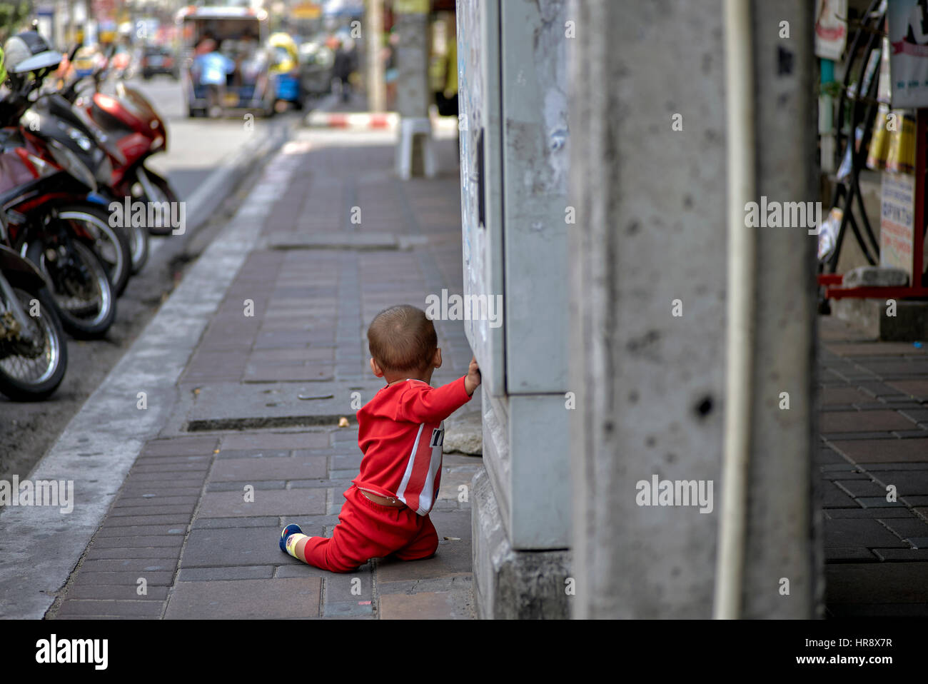 Child playing alone outside on the street. Pattaya Thailand Southeast ...