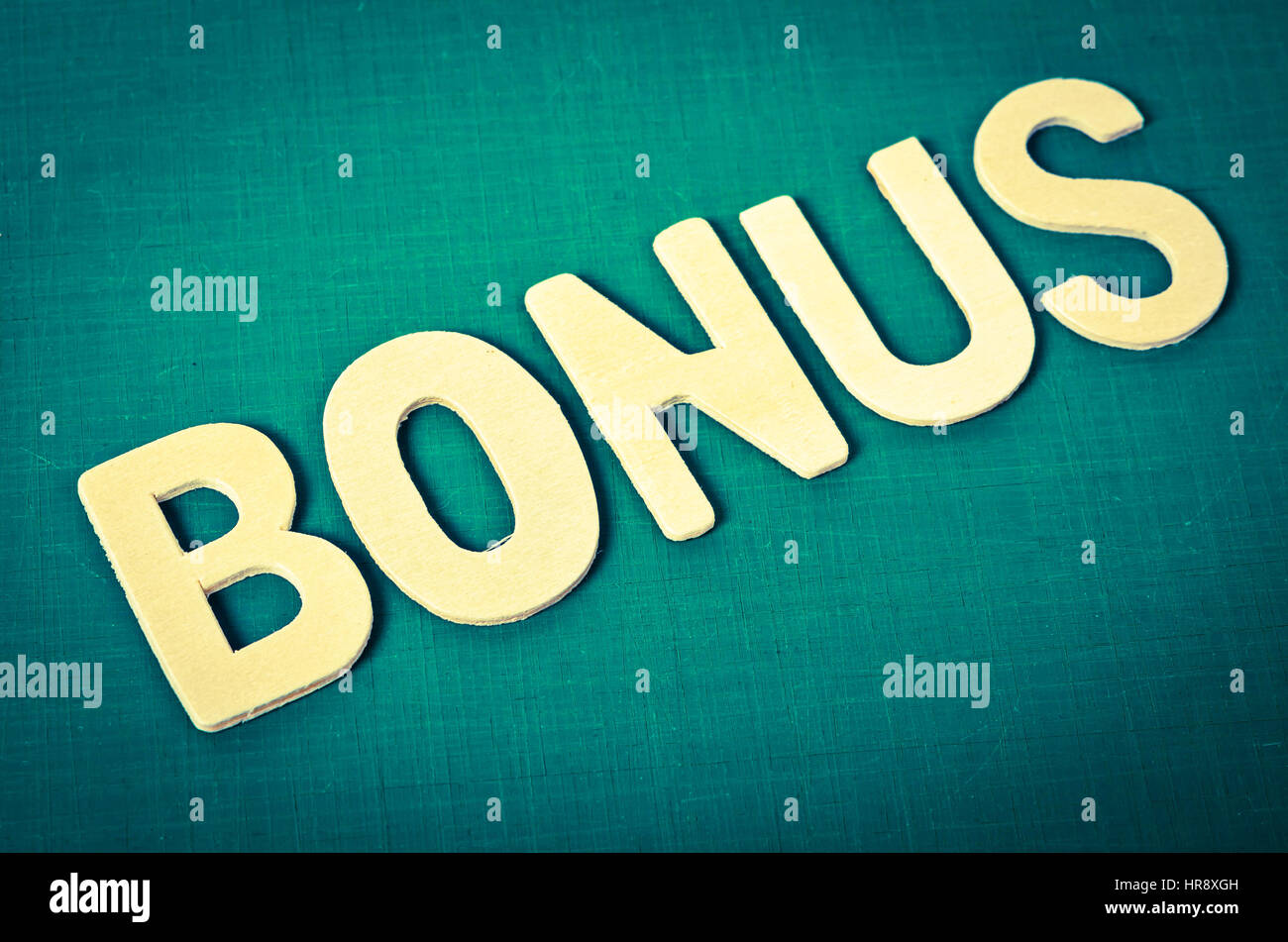 Bonus wooden word on green background Stock Photo - Alamy