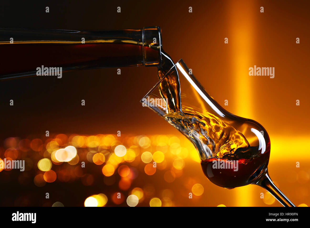 Pouring alcohol into a wineglass on the background of night city Stock ...