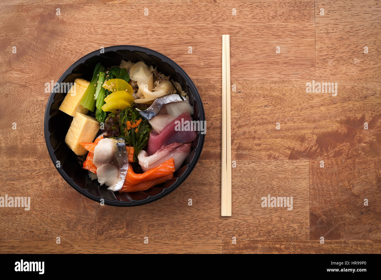 Japanese food Tekka Don take away on wooden background raw tuna salmon ...