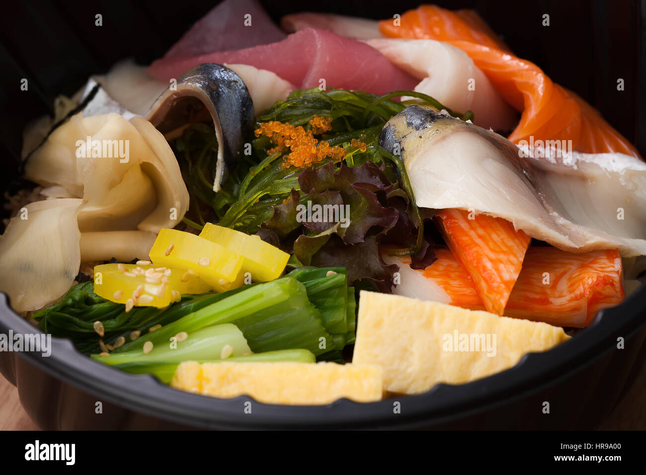 Japanese food Tekka Don take away on wooden background raw tuna salmon ...