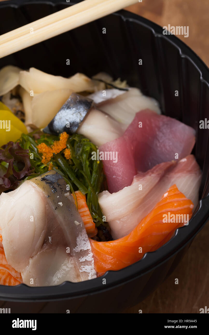 Japanese food Tekka Don take away on wooden background raw tuna salmon ...