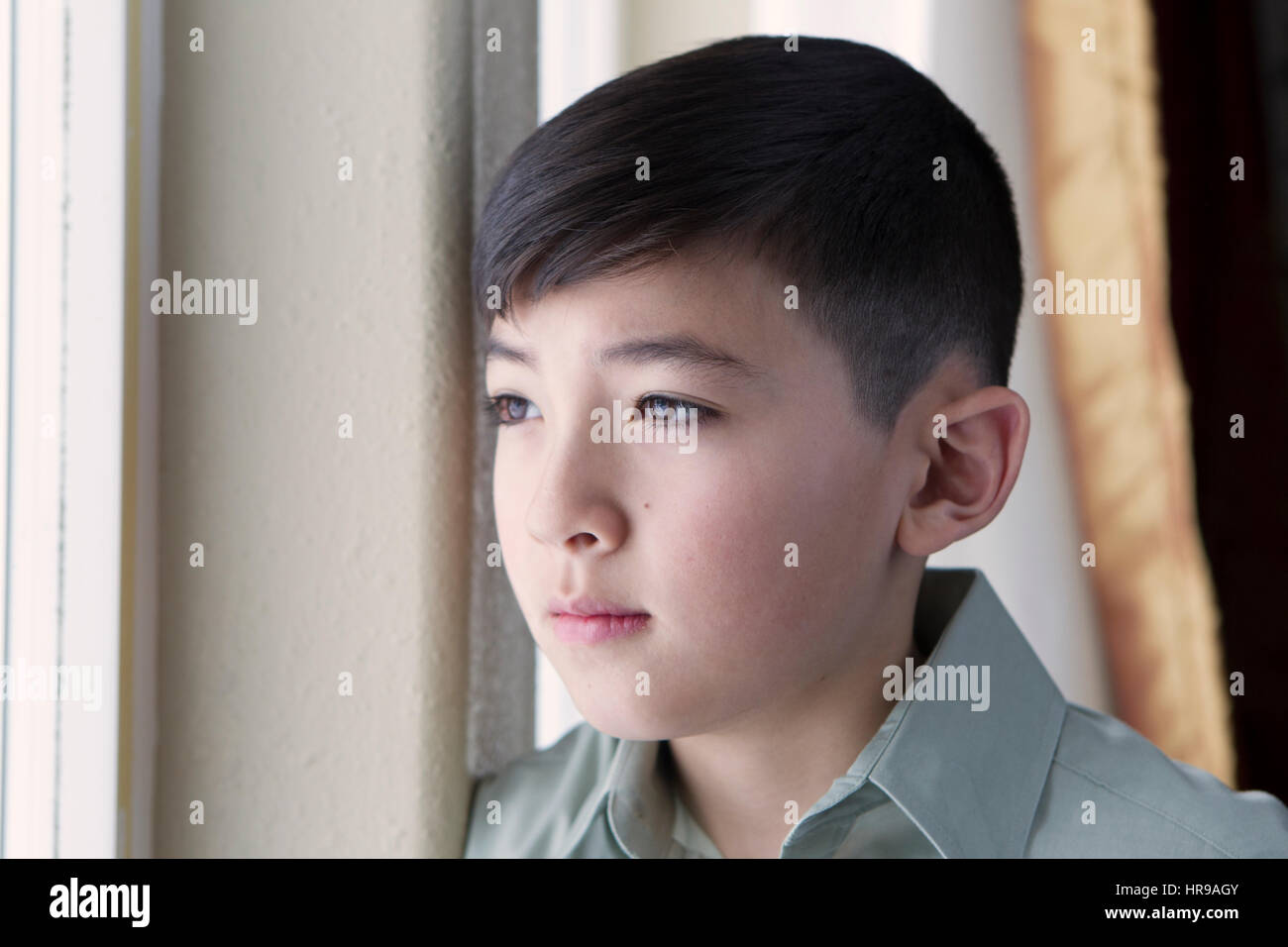 A young boy gazes out the window from inside Stock Photo - Alamy