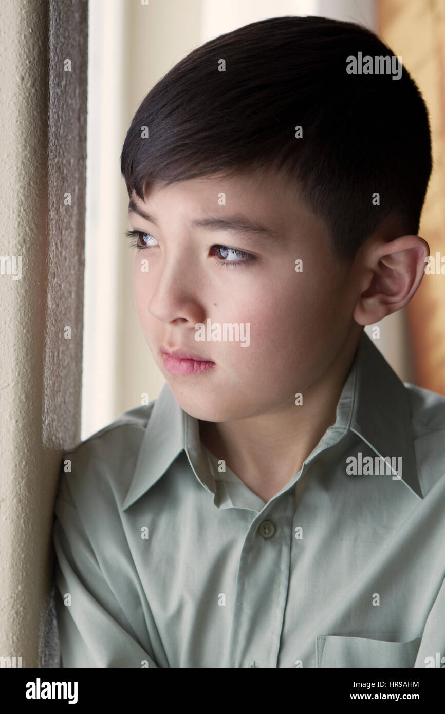 A young boy gazes out the window from inside Stock Photo - Alamy