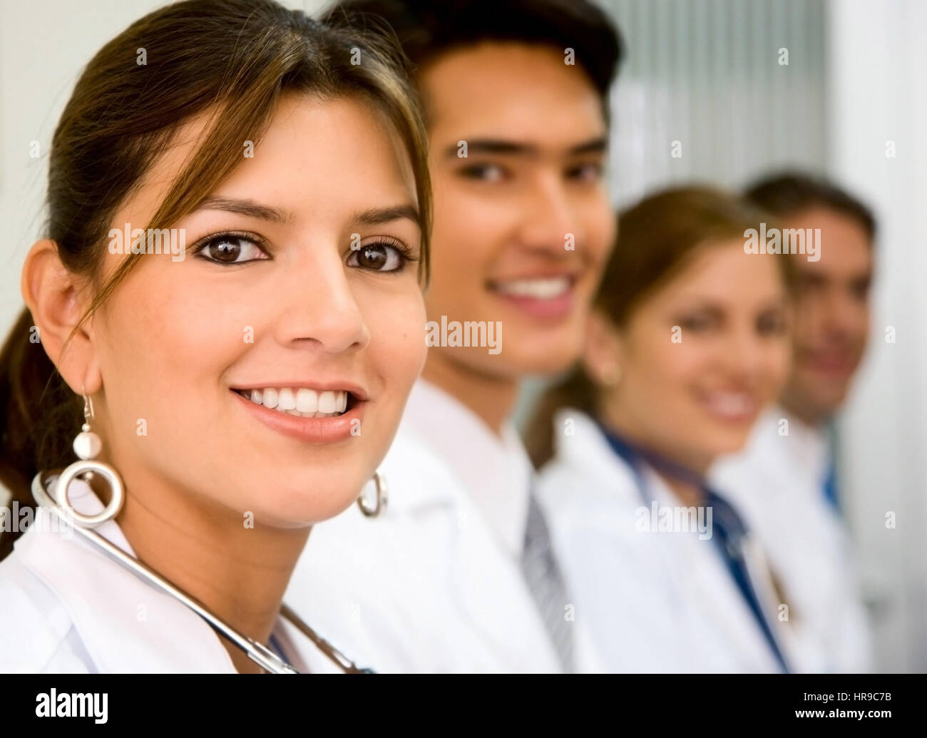 Beautiful female doctor facing the camera with her team behind her ...