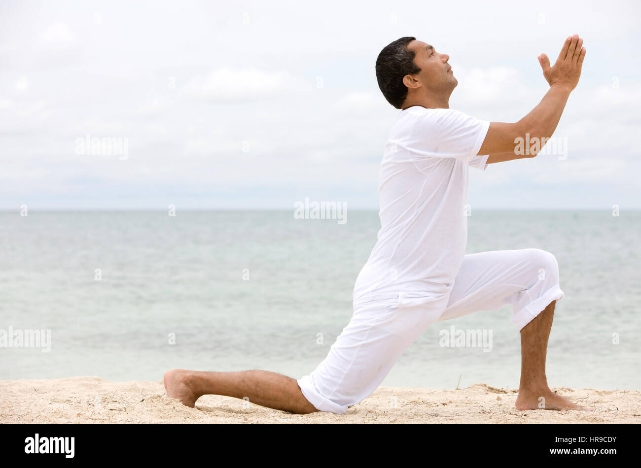 Beach man doing yoga exercises in a tranquil location Stock Photo - Alamy