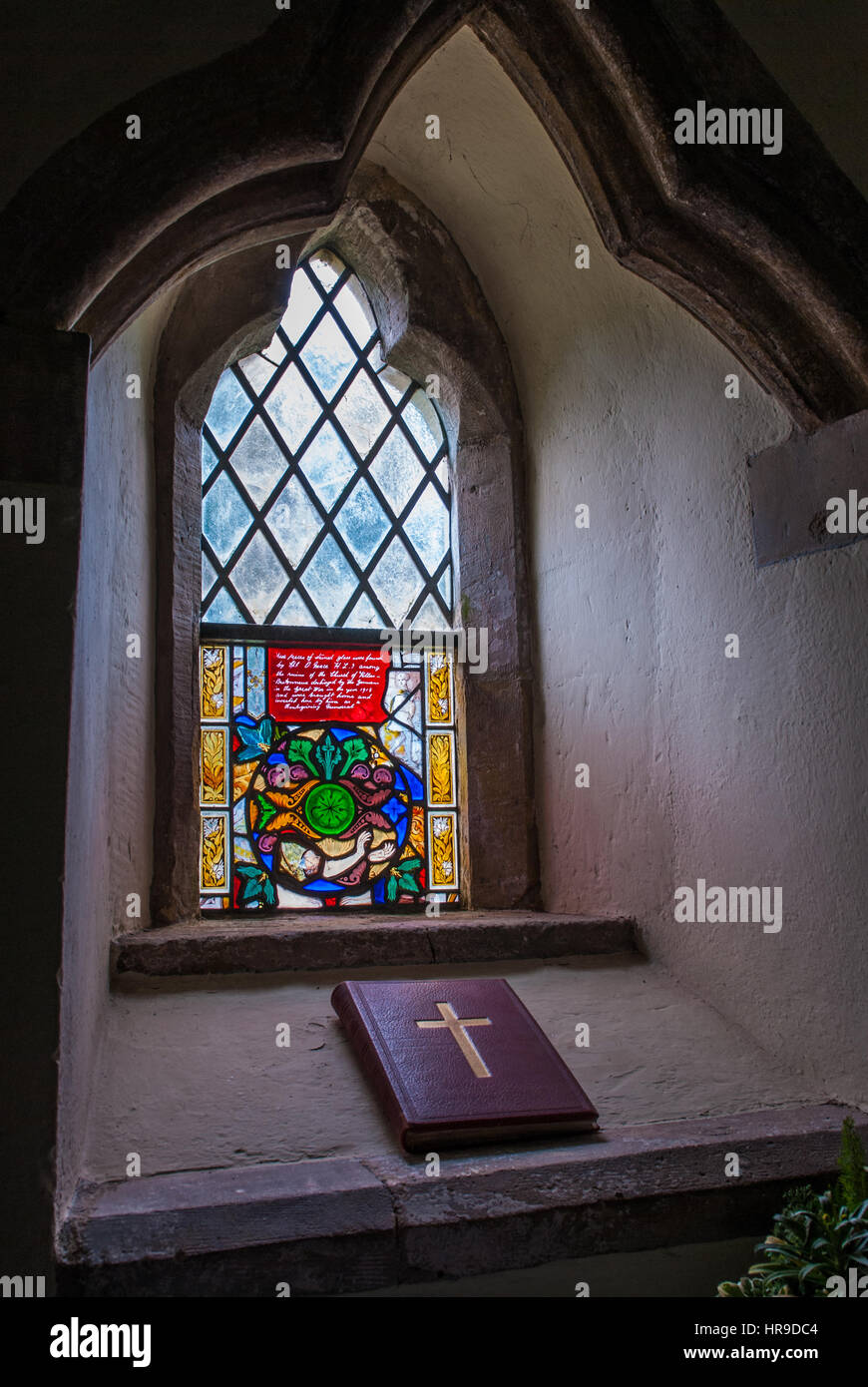 The bible on display in a church window set against a stained glass ...